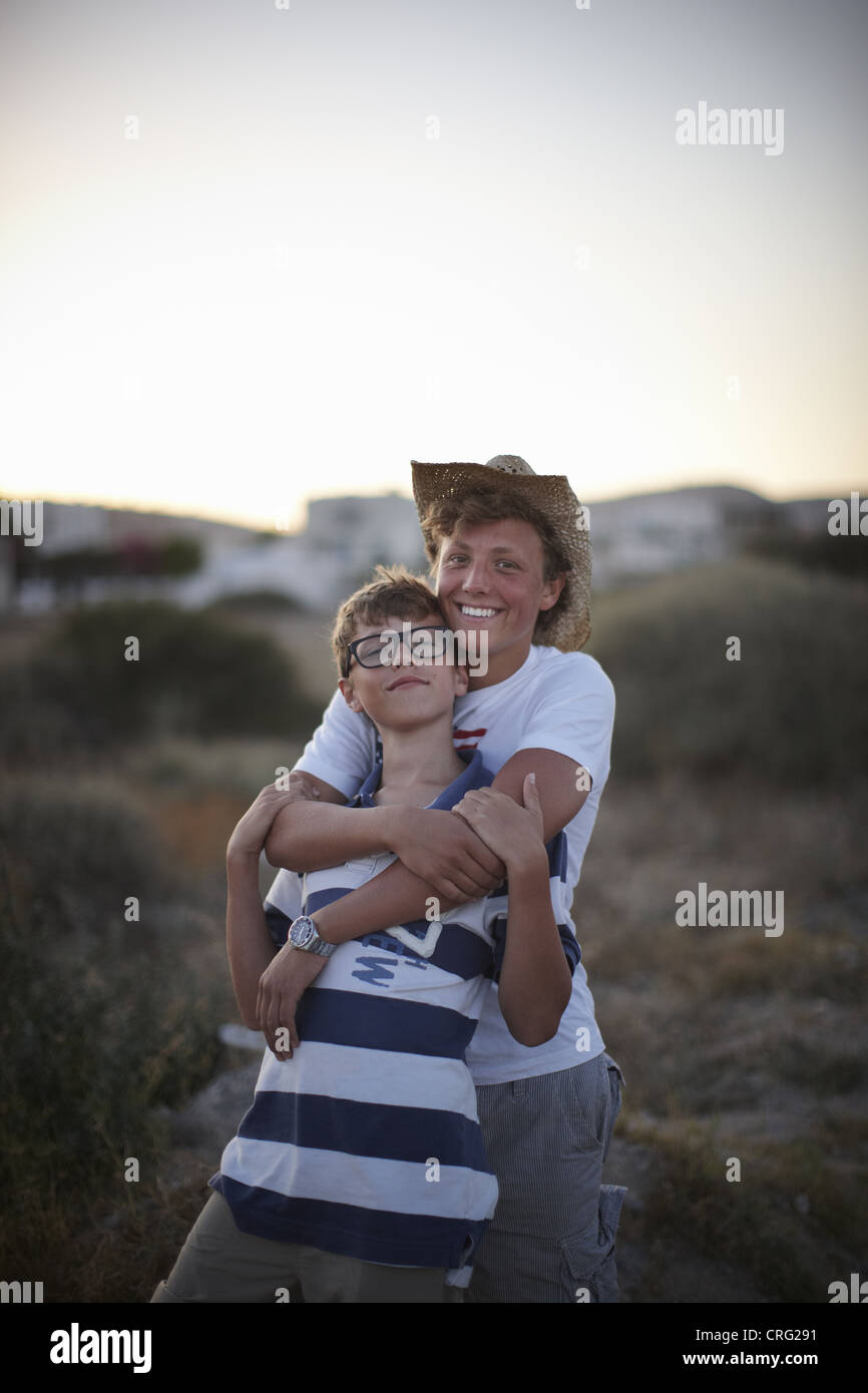 Smiling brothers hugging outdoors Stock Photo - Alamy