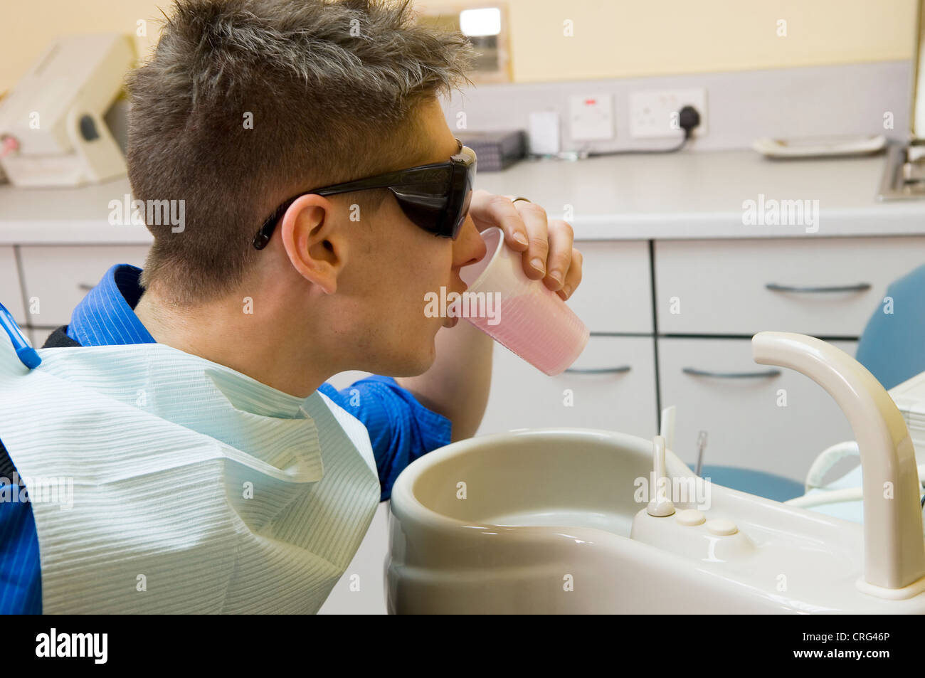 Young male patient rinses his mouth after dental treatment Stock Photo ...