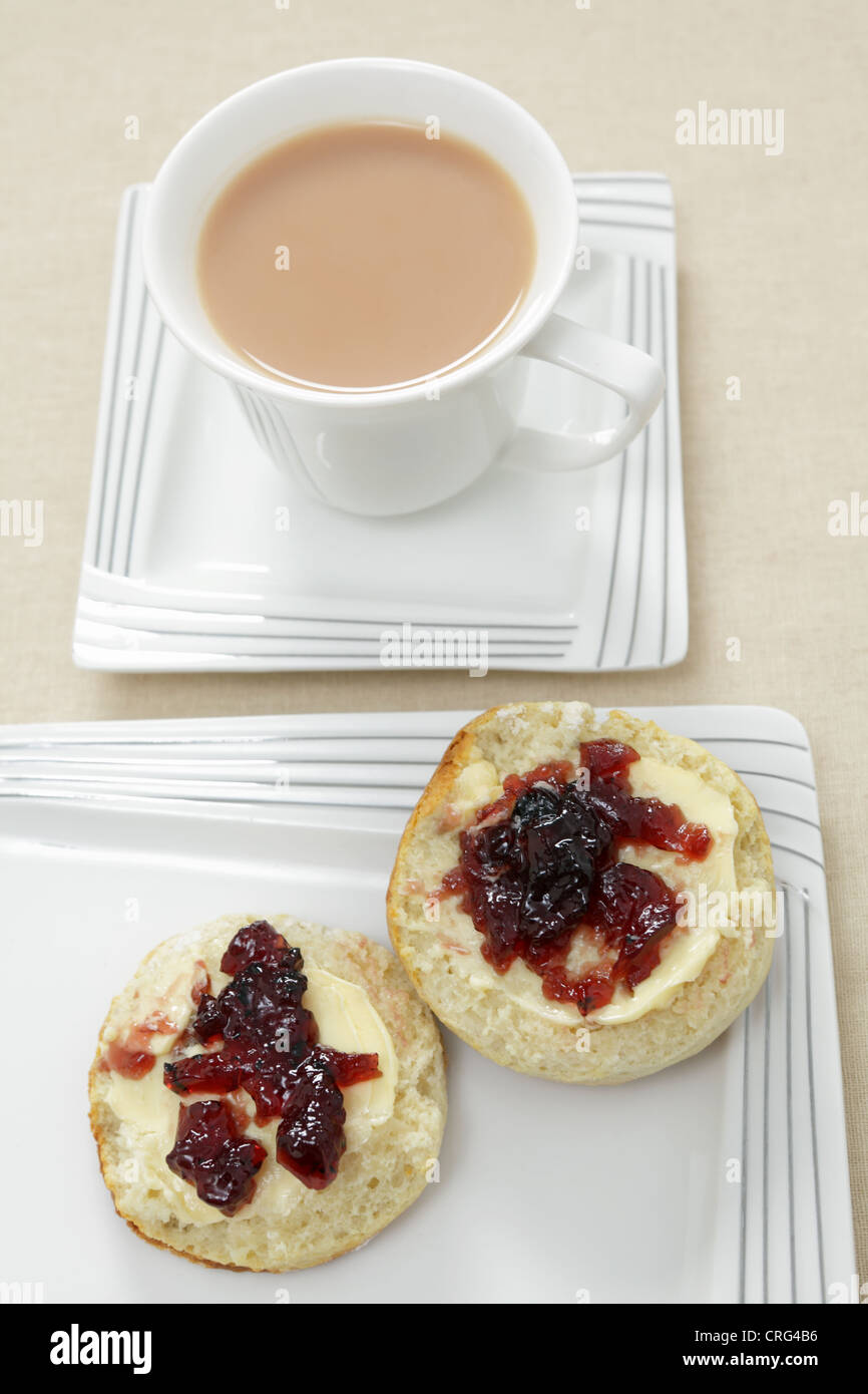 A traditional English afternoon tea of a scone topped with butter and ...