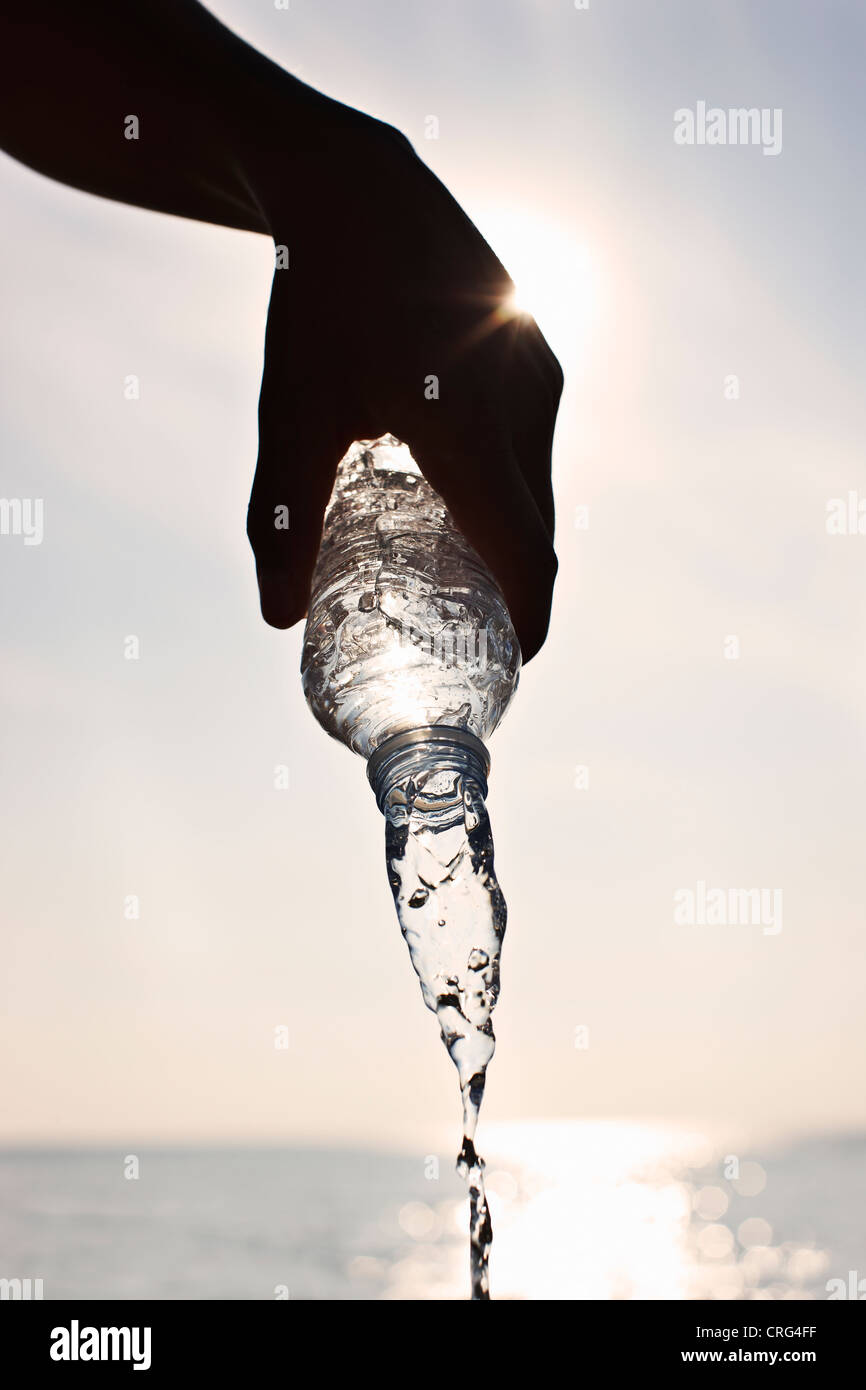 Teenage boy pouring water out of bottle Stock Photo - Alamy