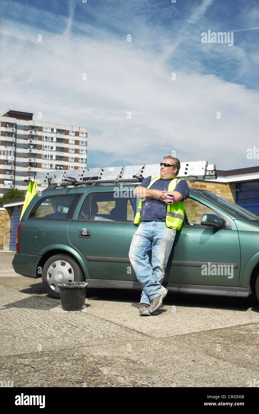 Worker leaning against car on site Stock Photo - Alamy