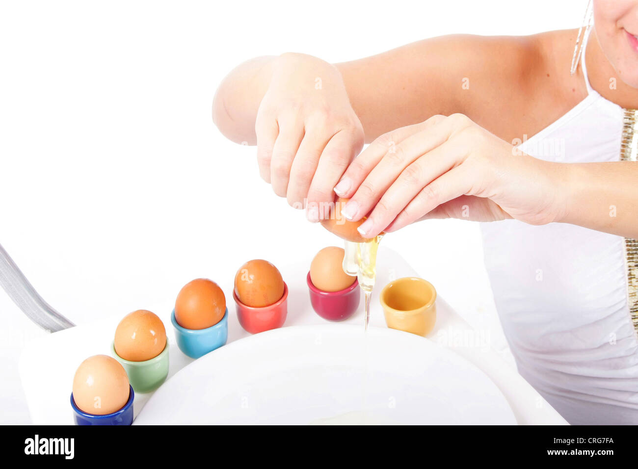 young woman opens eggs, pouring out the yellow of an egg Stock Photo ...