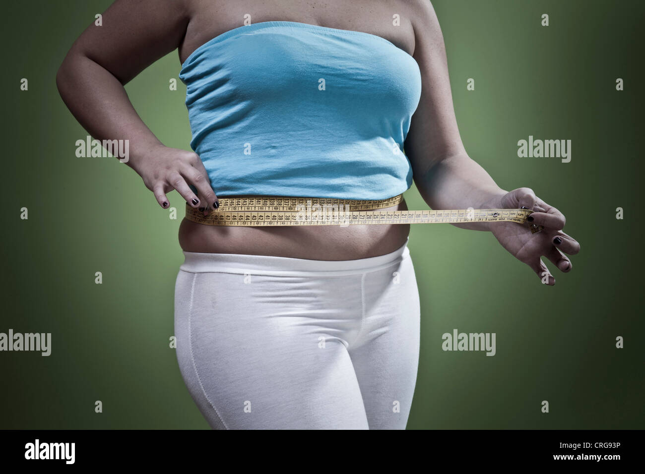 Woman measuring her waistline Stock Photo - Alamy
