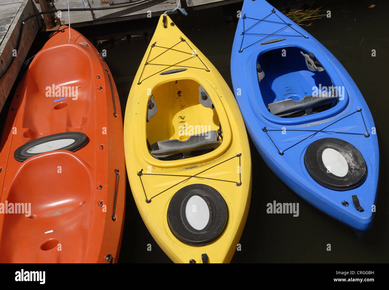 Three brightly coloured canoes Stock Photo - Alamy