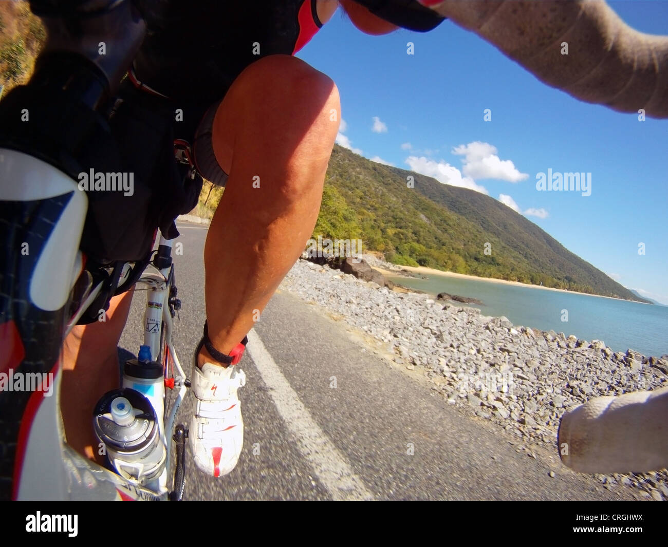 Cyclist enjoying the scenic Captain Cook Highway between Cairns and ...