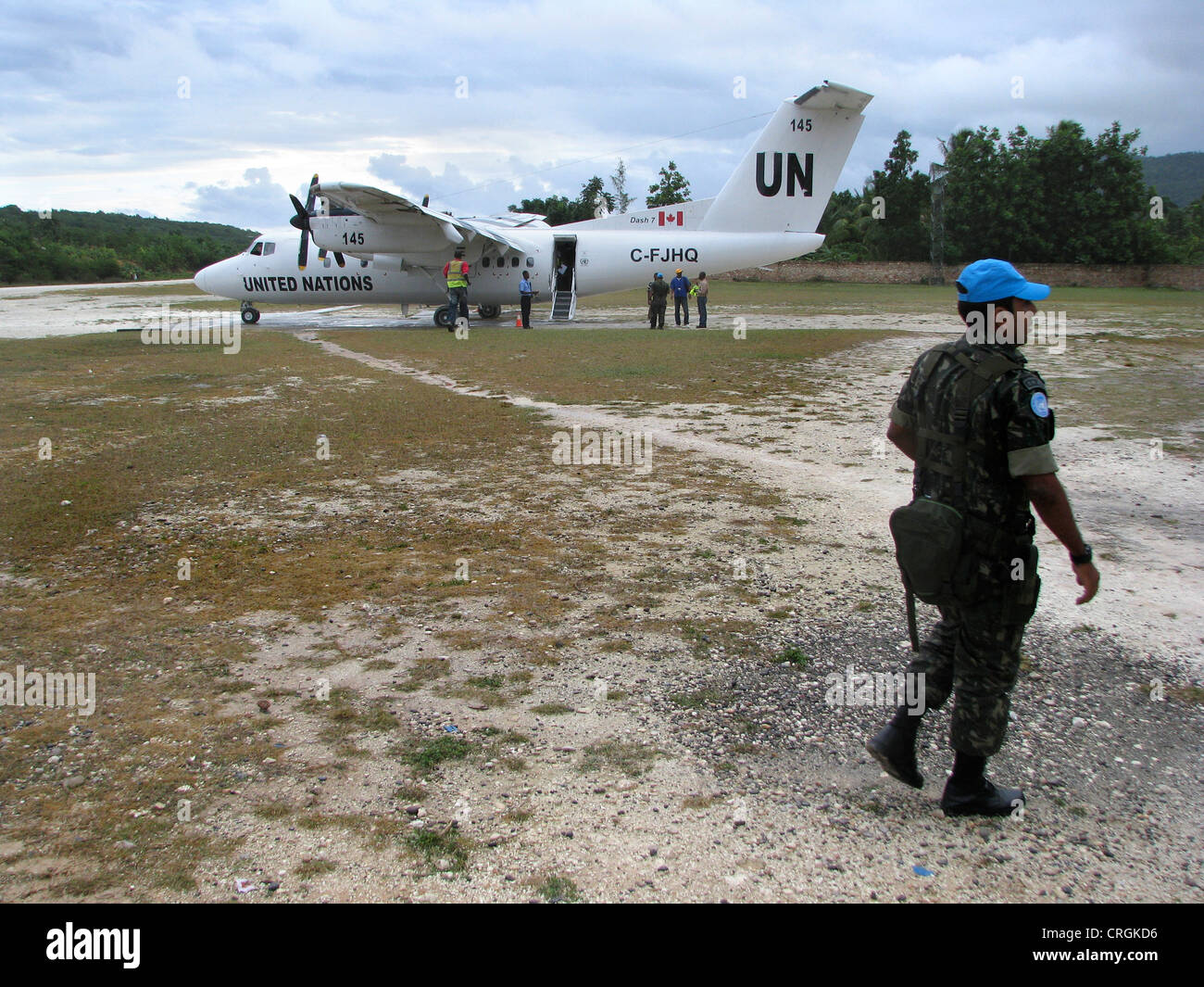 people around a UN plane, guarded by a soldier of the 'United Nations ...