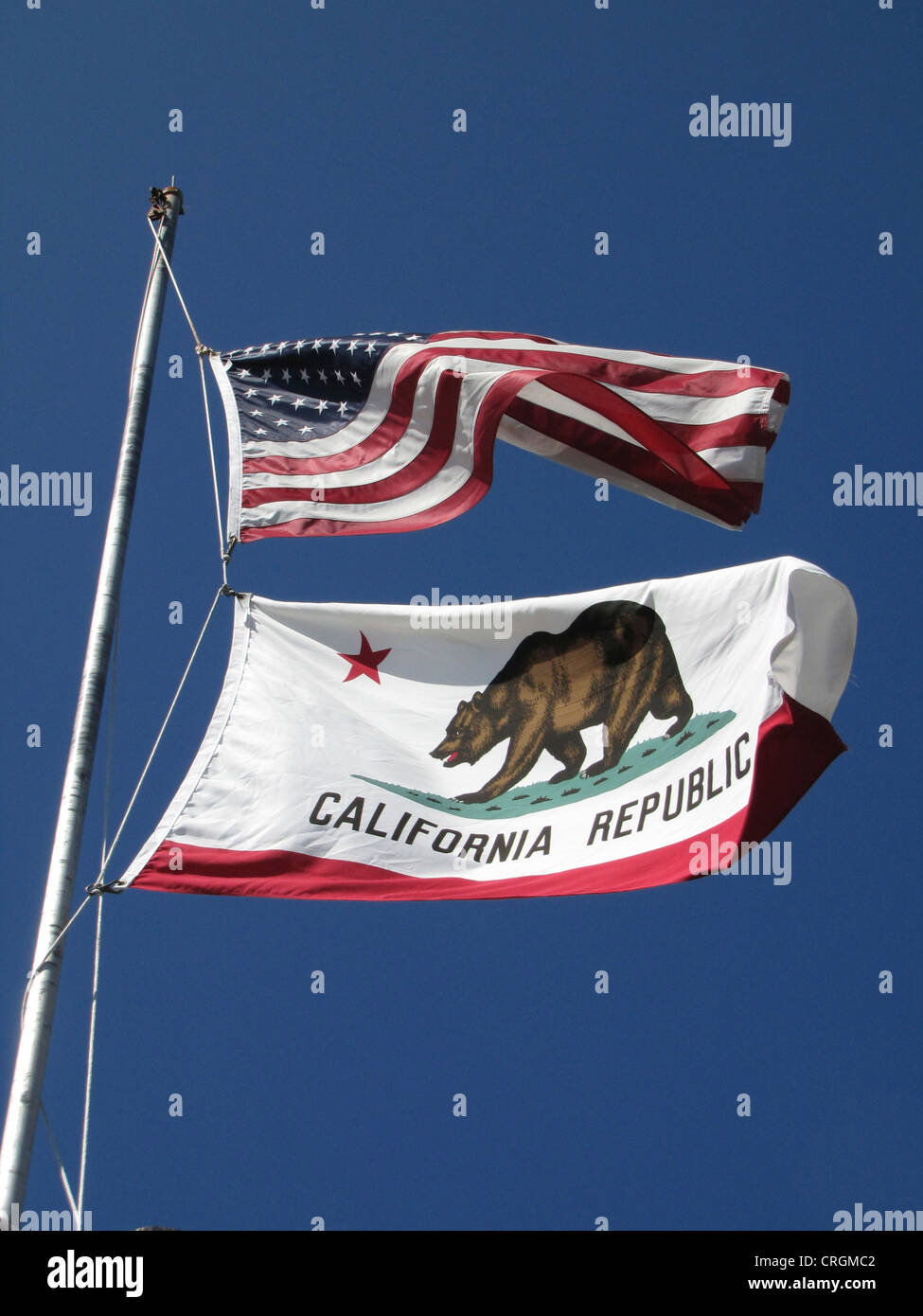 Flags of the USA and of the state of California in front of blue sky ...