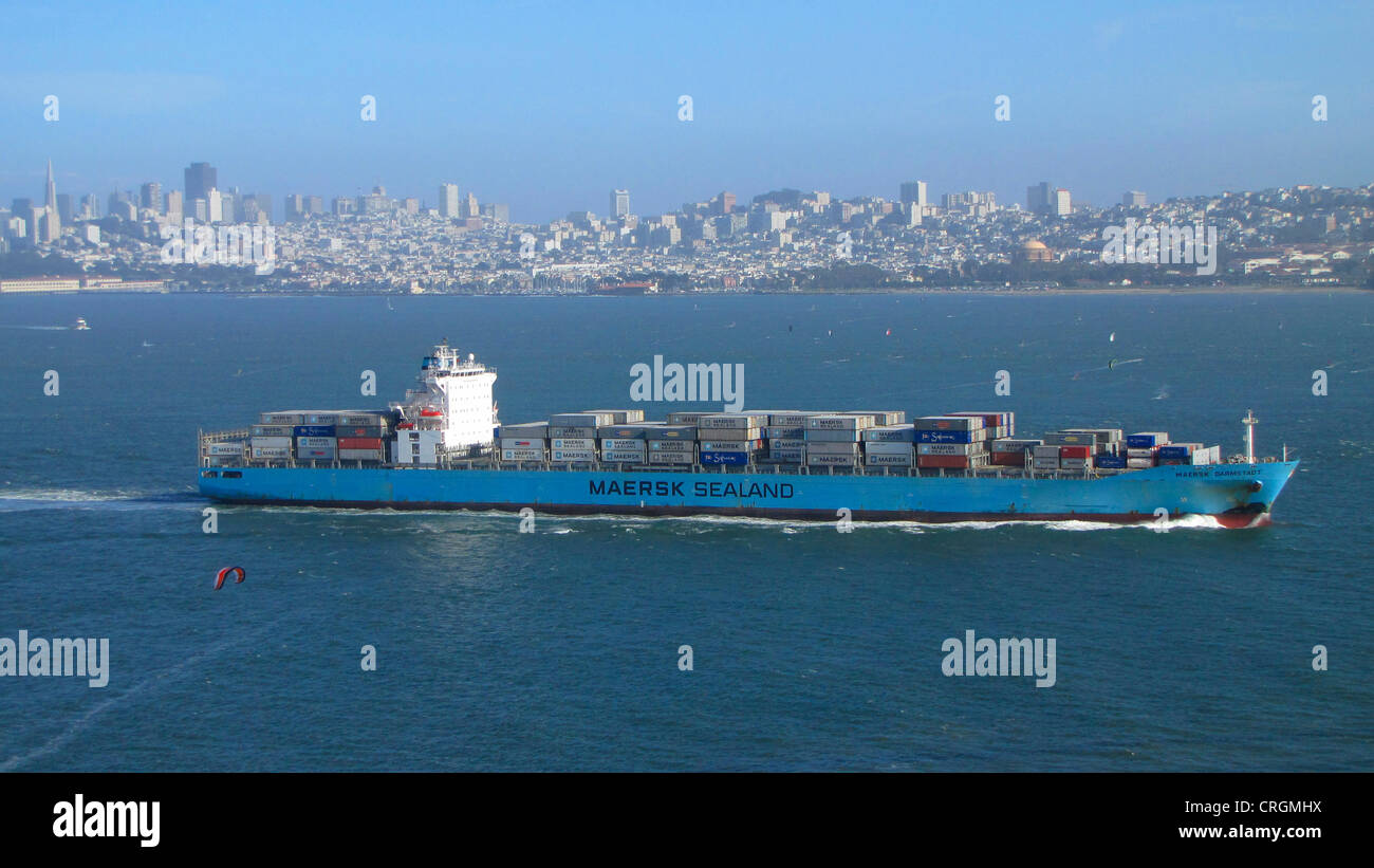 Large cargo ship with freight containers in front of skyline of San ...