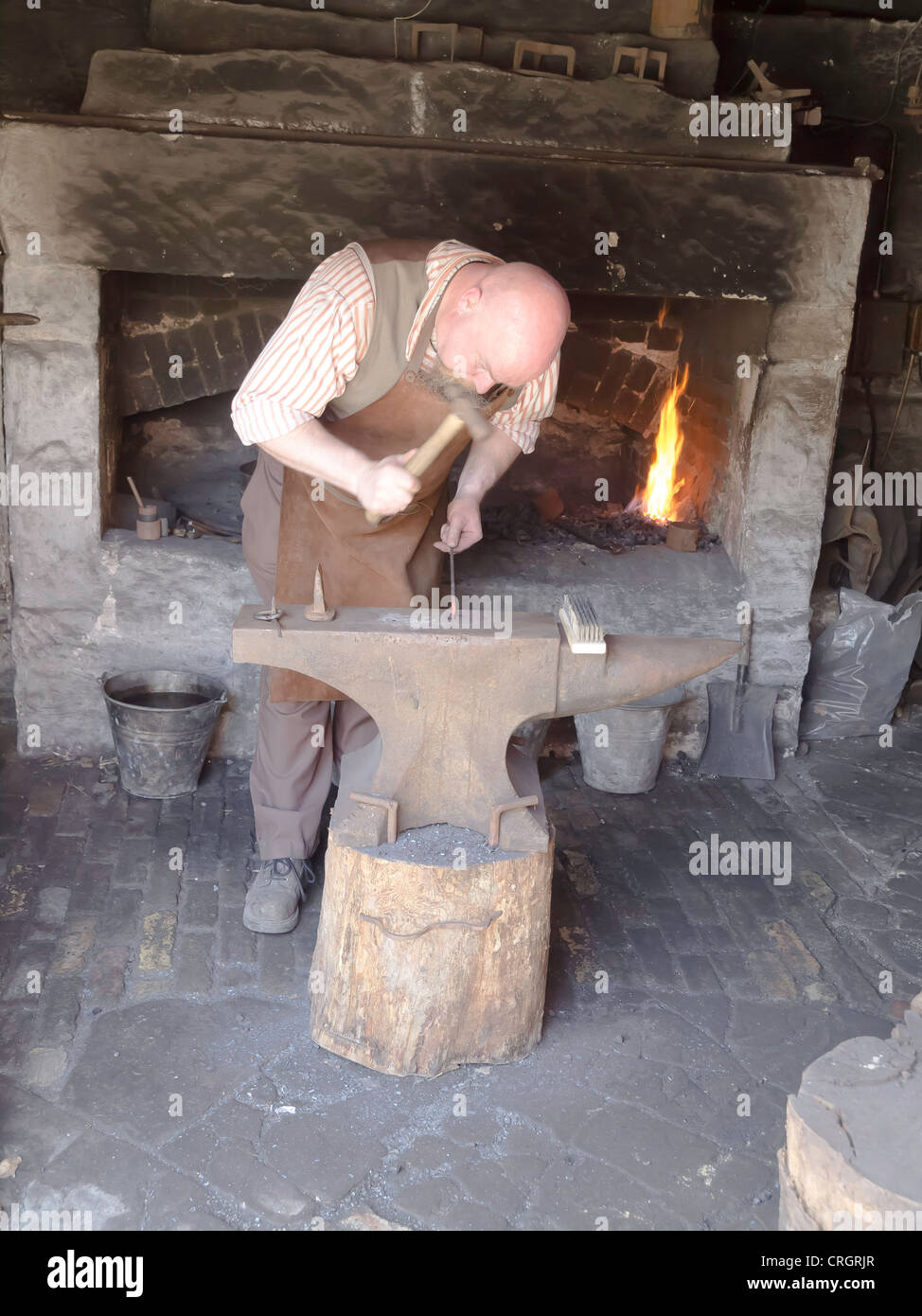 A blacksmith working at his forge in Home Farm at Beamish Museum of ...