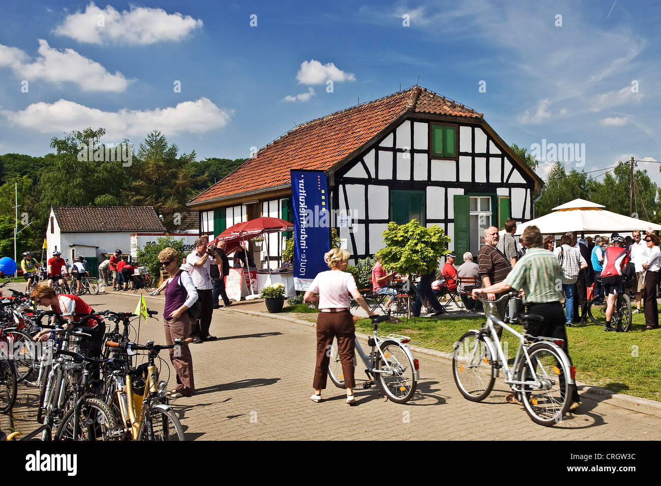 visitors on bicycle festival at old half-timbered house next to Ruhr ...