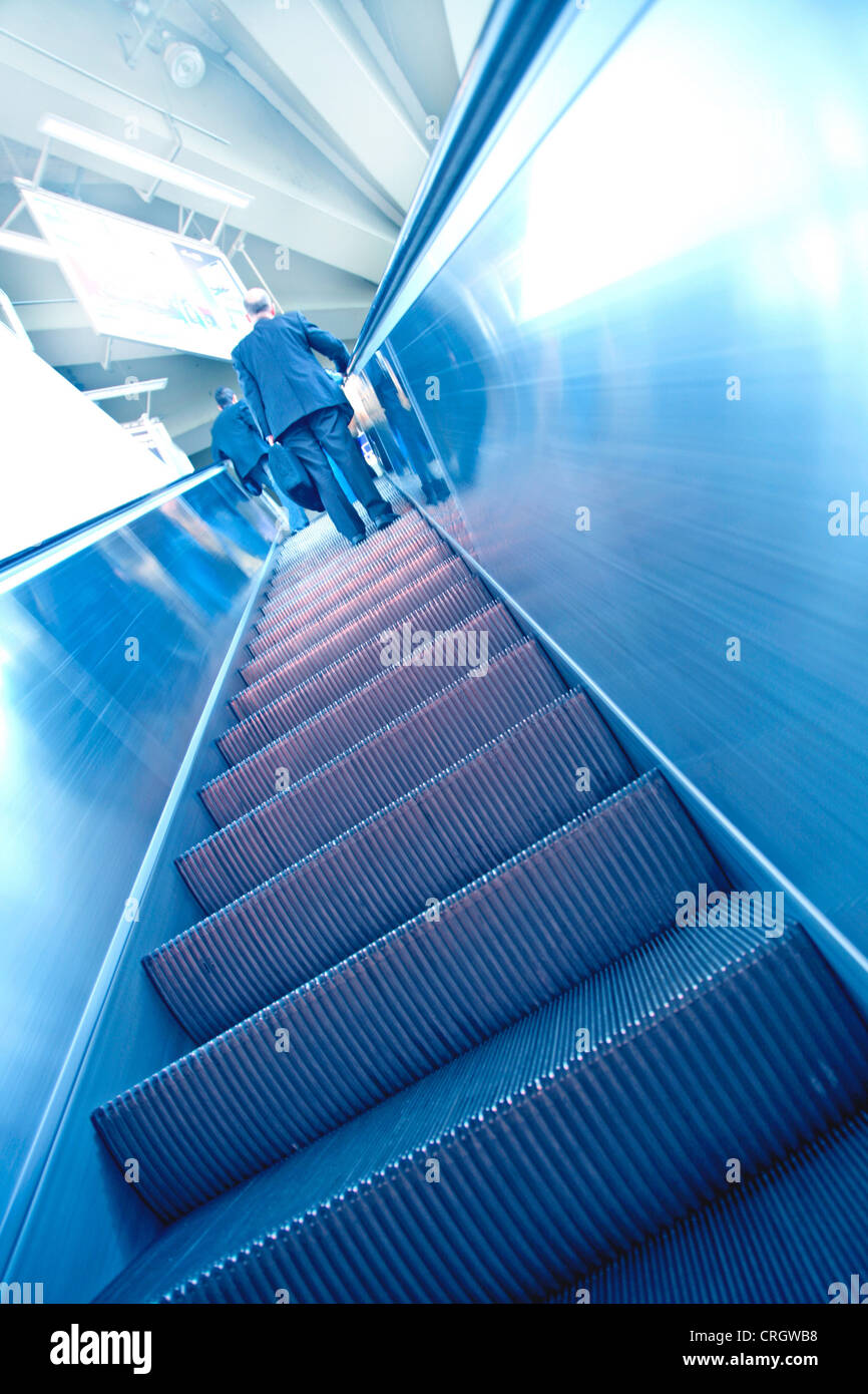 two men in suits going up moving stairs Stock Photo - Alamy