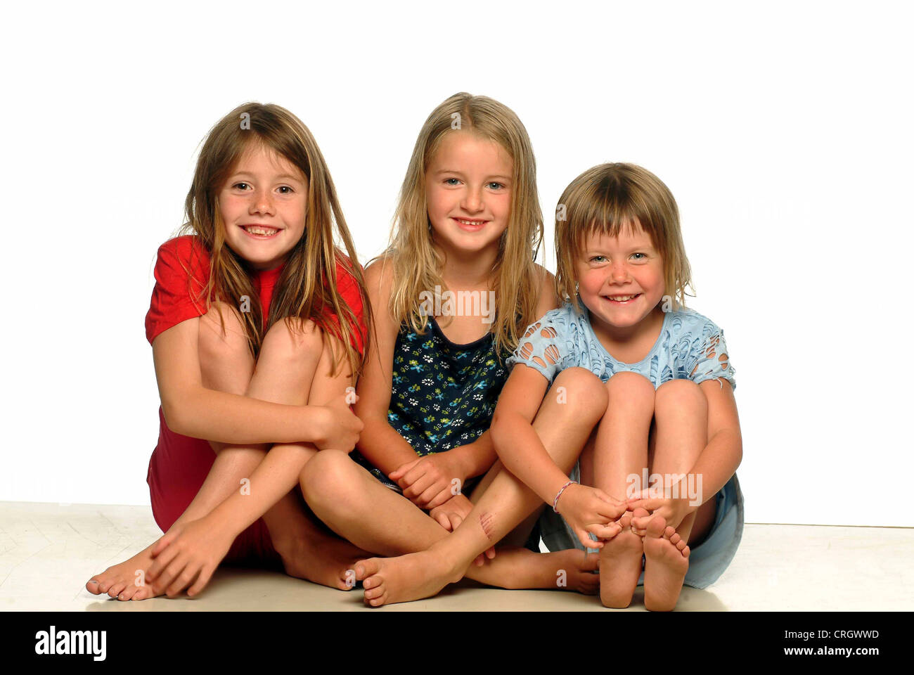 three little girls sitting side by side barefoot Stock Photo: 48929369 ...