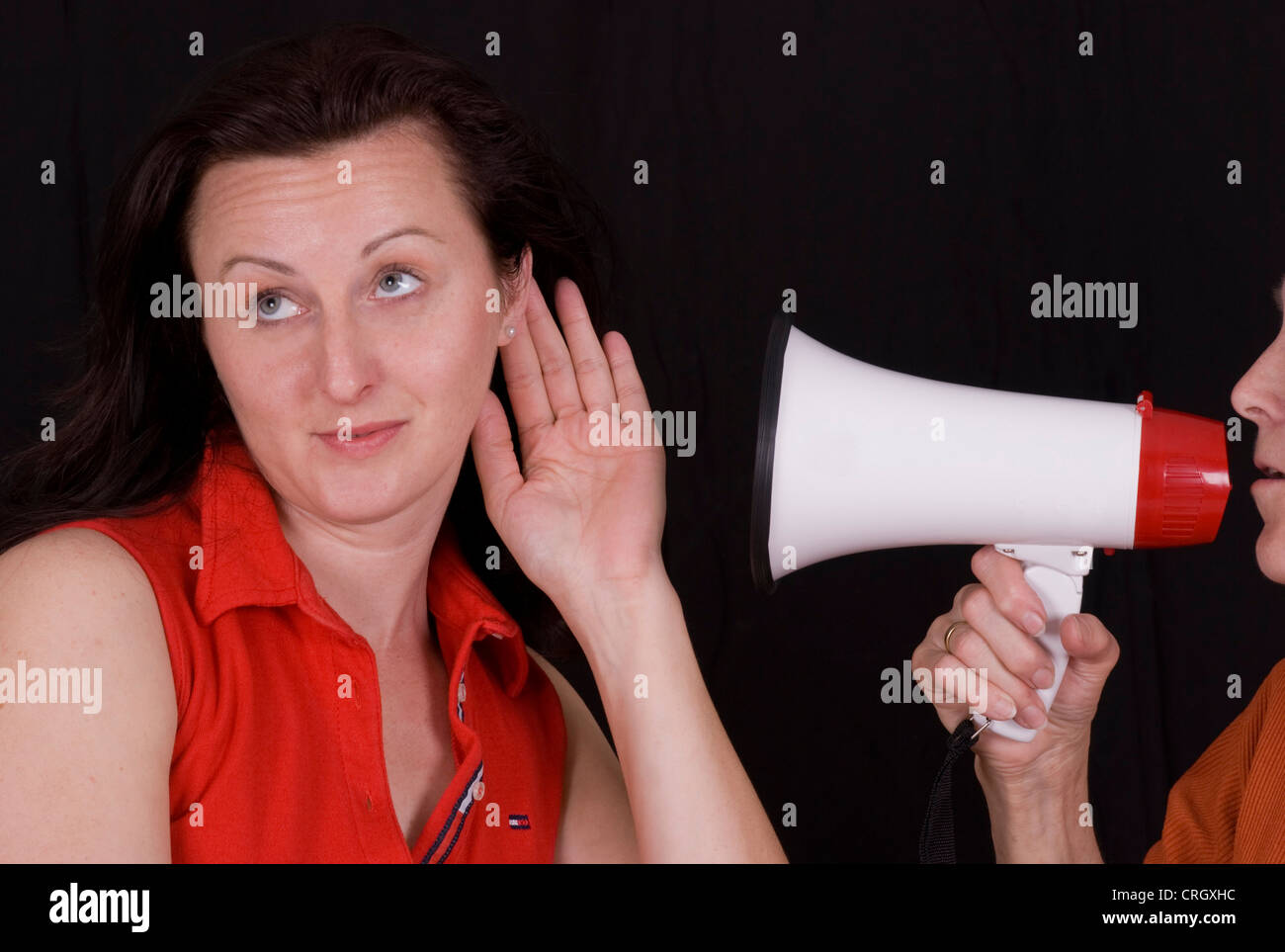 woman shouting into a megaphone to young woman Stock Photo - Alamy