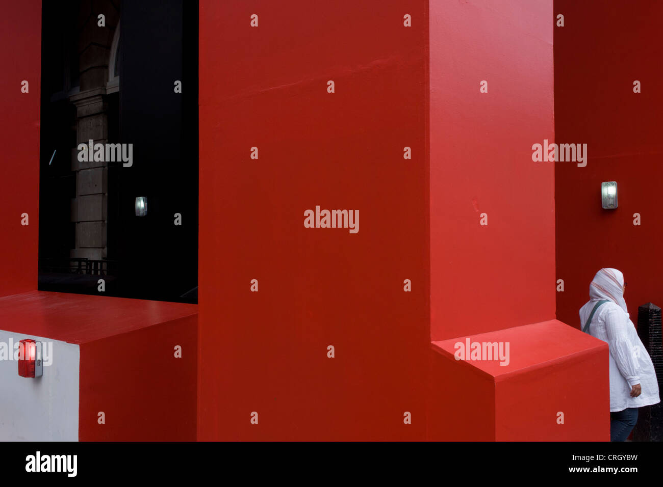 Red construction safety hoarding and Muslim woman in a central London ...