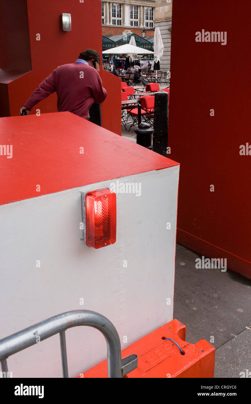 Red construction safety hoarding and phone man in a central Covent ...