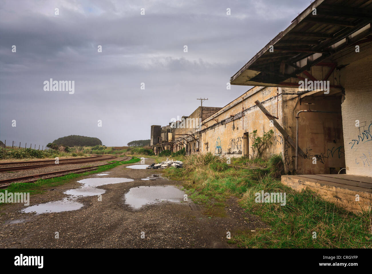 Abandoned factory on a wet day, gray sky, puddles on the ground ...
