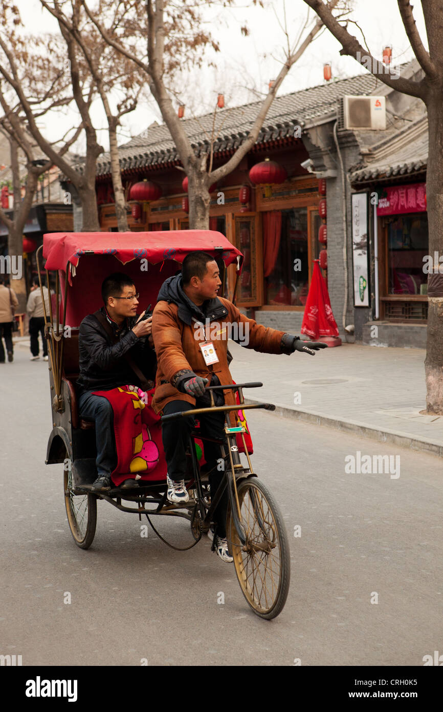 Rickshaw driver taking tourist for Hutong tour, Beijing China Asia ...