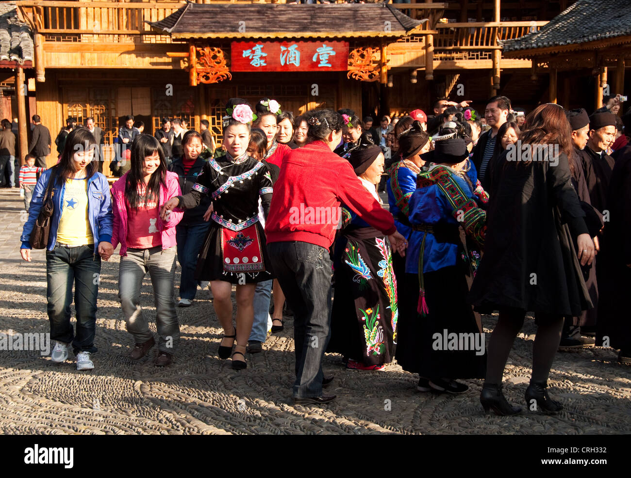 Miao dancers in traditional costumes dancing with Chinese tourists ...