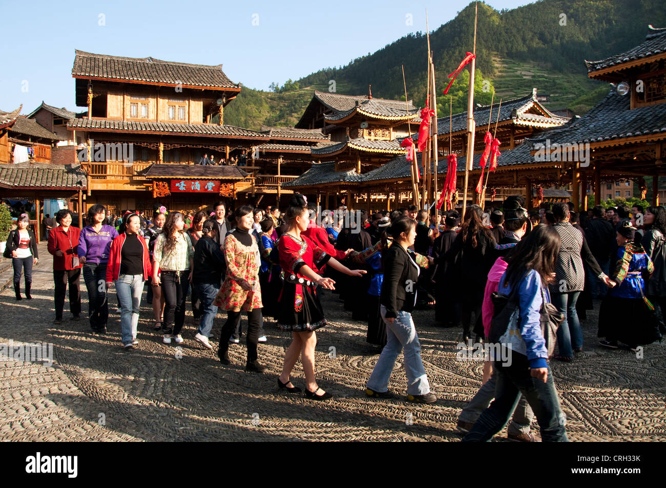 Miao dancers in traditional costumes dancing with Chinese tourists ...