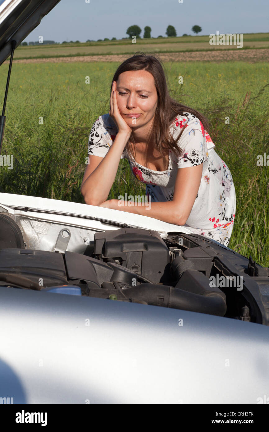 Woman watching the engine of a broken car Stock Photo - Alamy