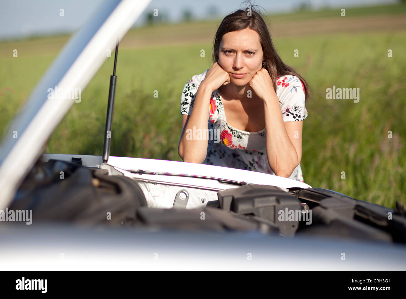 Woman watching the engine of a broken car Stock Photo - Alamy