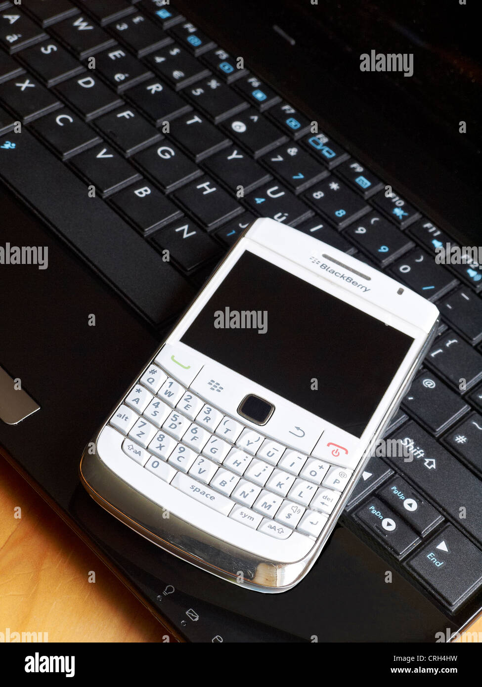 Blackberry mobile phone on netbook keyboard Stock Photo - Alamy