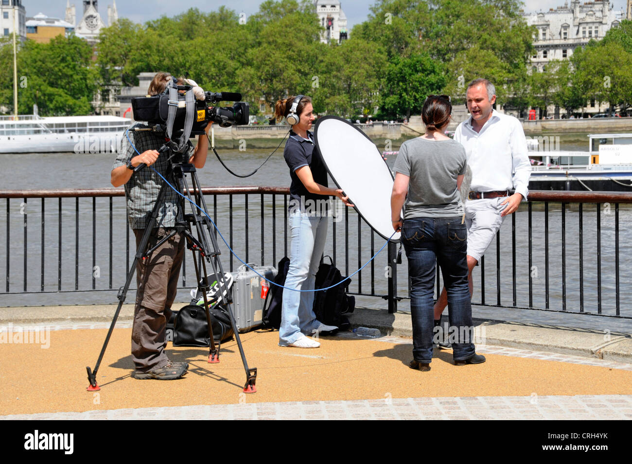 Camera crew filming an interview beside the River Thames Stock Photo ...
