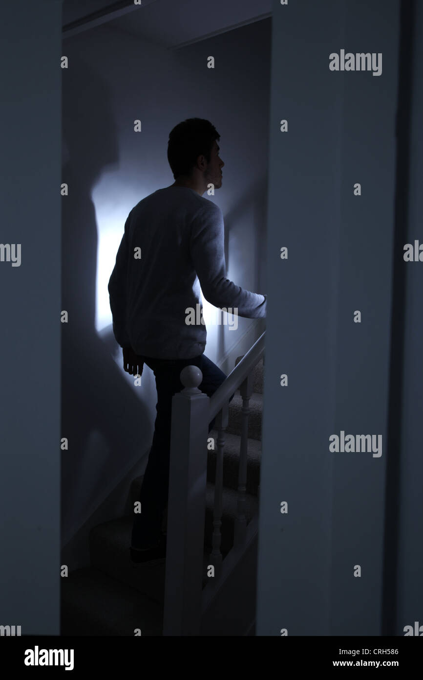 Young man walking upstairs Stock Photo - Alamy