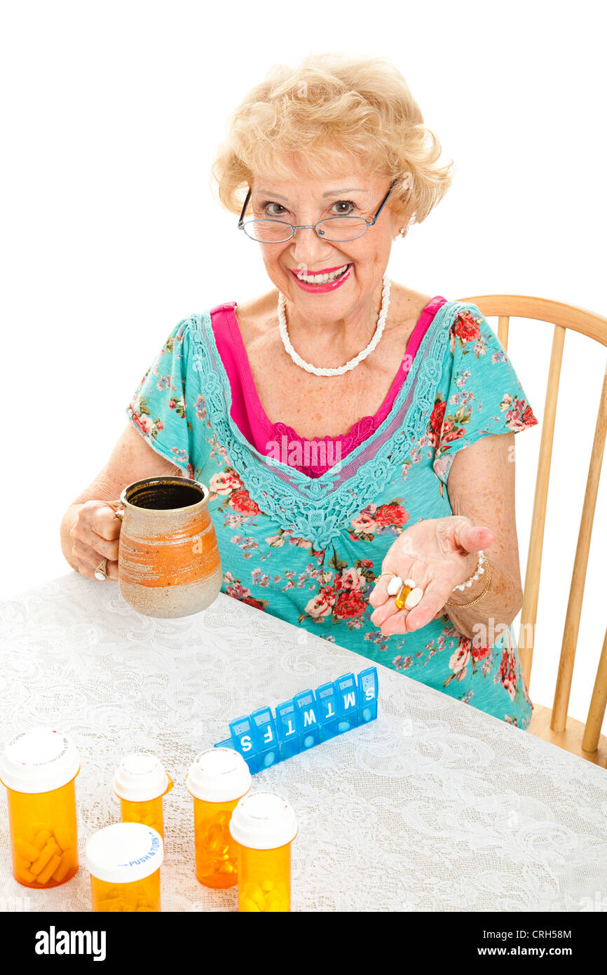 Smiling senior lady cheerfully takes her prescriptions and suppliments ...