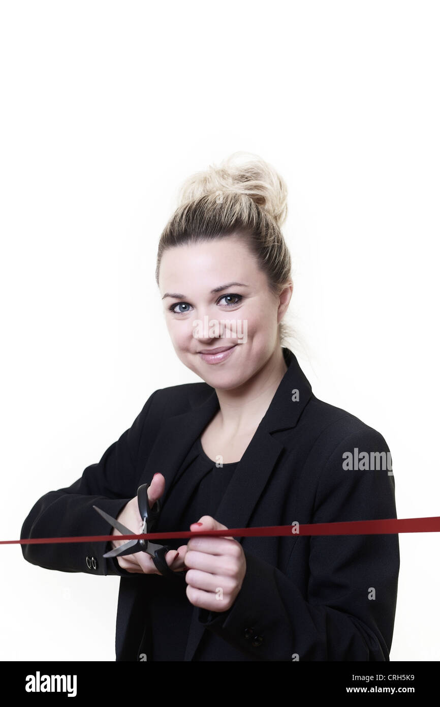 woman standing cutting ribbon with a pair of scissors Stock Photo - Alamy