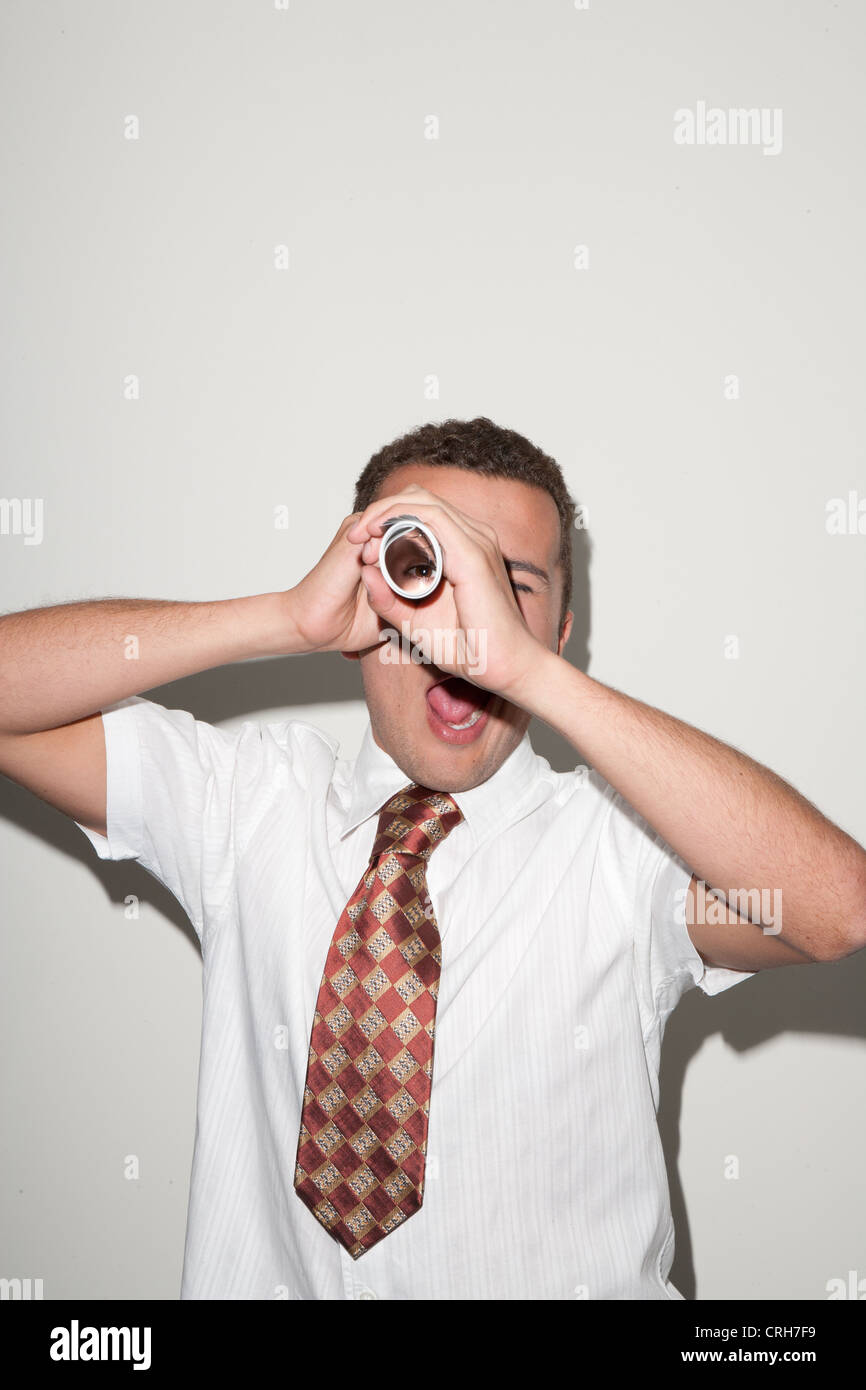 Young businessman looking through a rolled up paper Stock Photo - Alamy