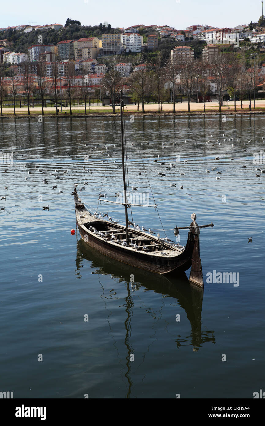 A wooden boat floats on the River Mondego in Coimbra, Portugal Stock ...