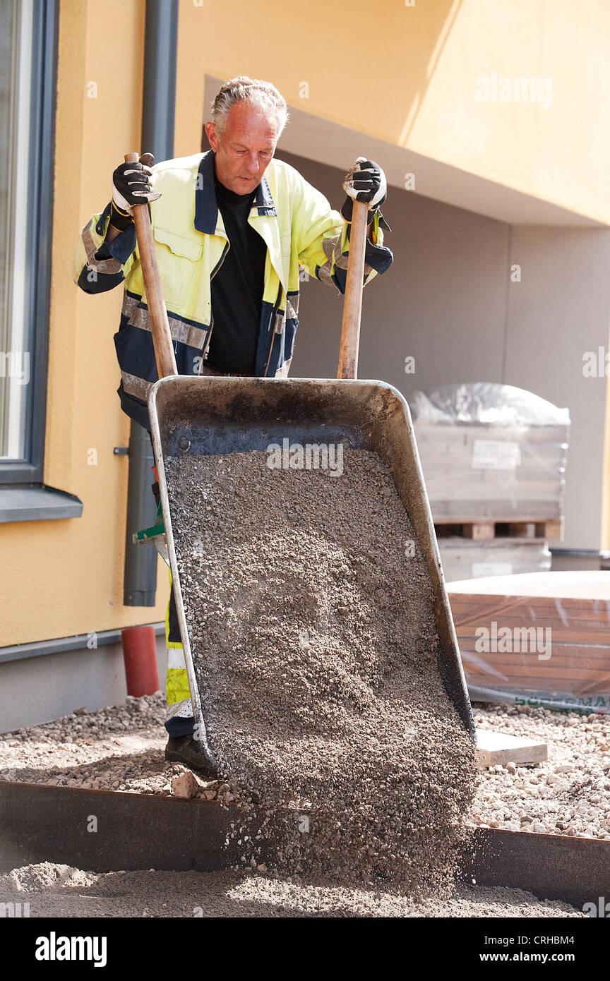 Man with a wheelbarrow Stock Photo - Alamy