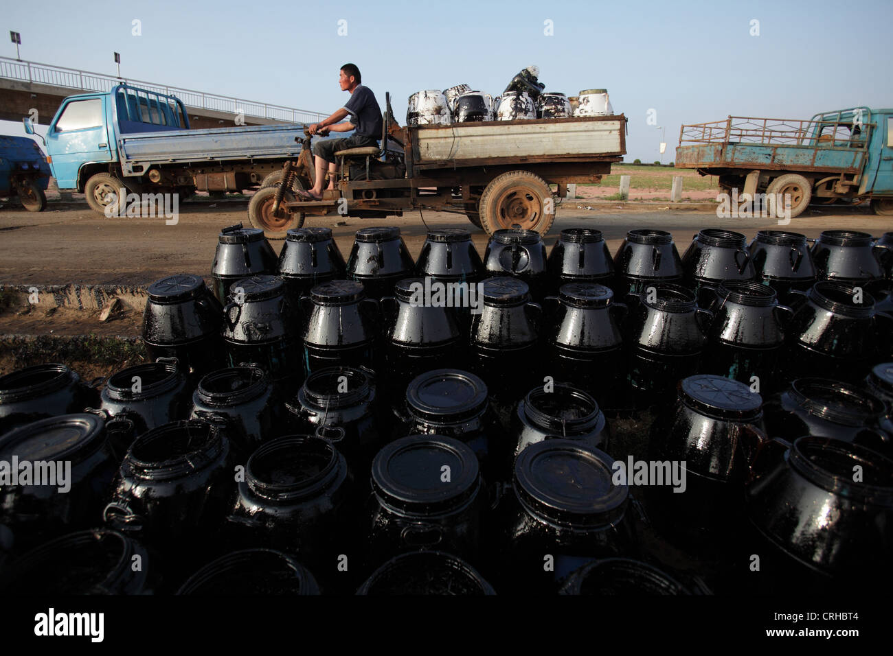 A man drives past barrels of recovered oil during the oil spill ...
