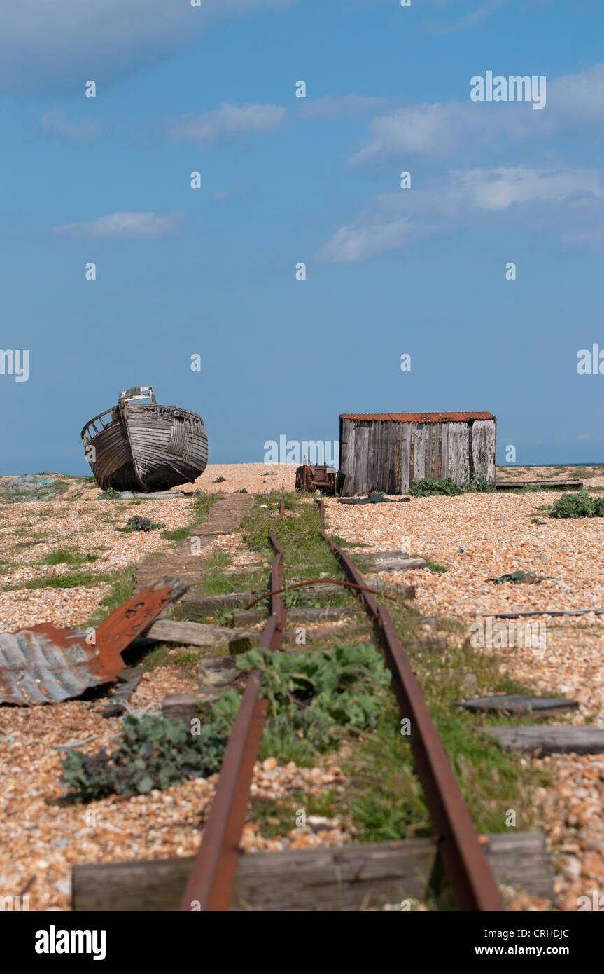 Derelict hut and abandoned old boat next to a rusty narrow gauge track ...