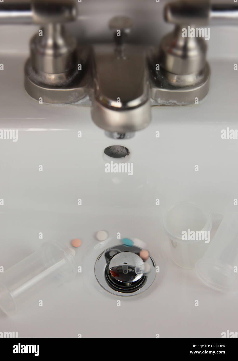 we see a sink drain and faucet. In the sink someone has thrown drugs ...