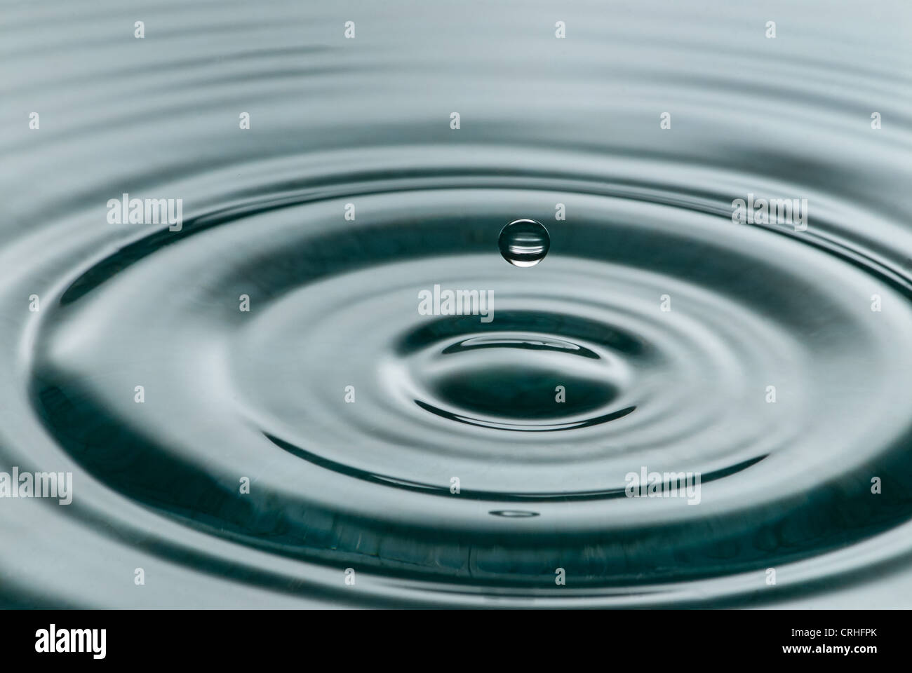 Falling water drops making ripples in the water Stock Photo - Alamy