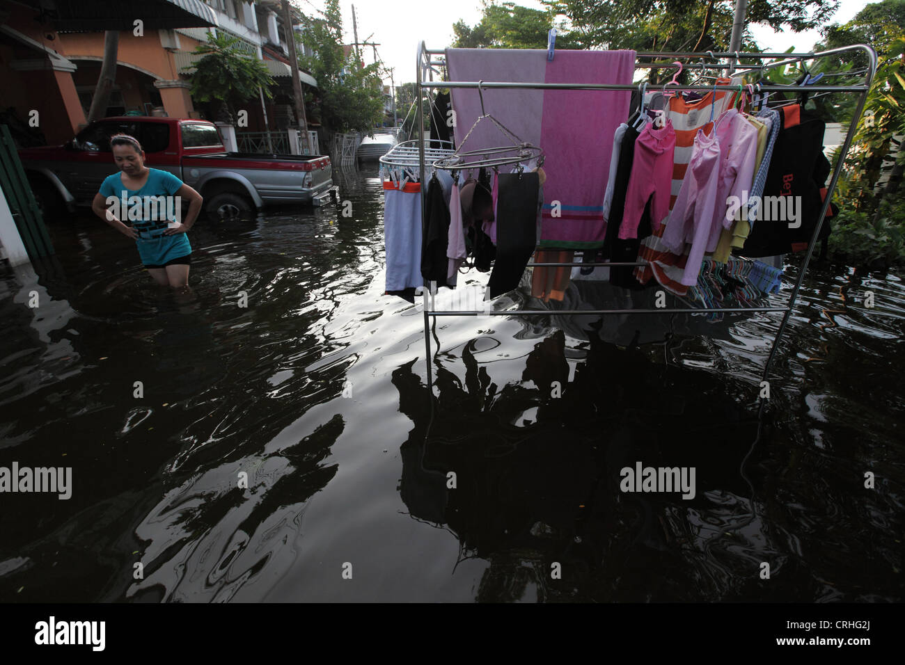 A woman hangs her clothes out on flooded streets Stock Photo - Alamy