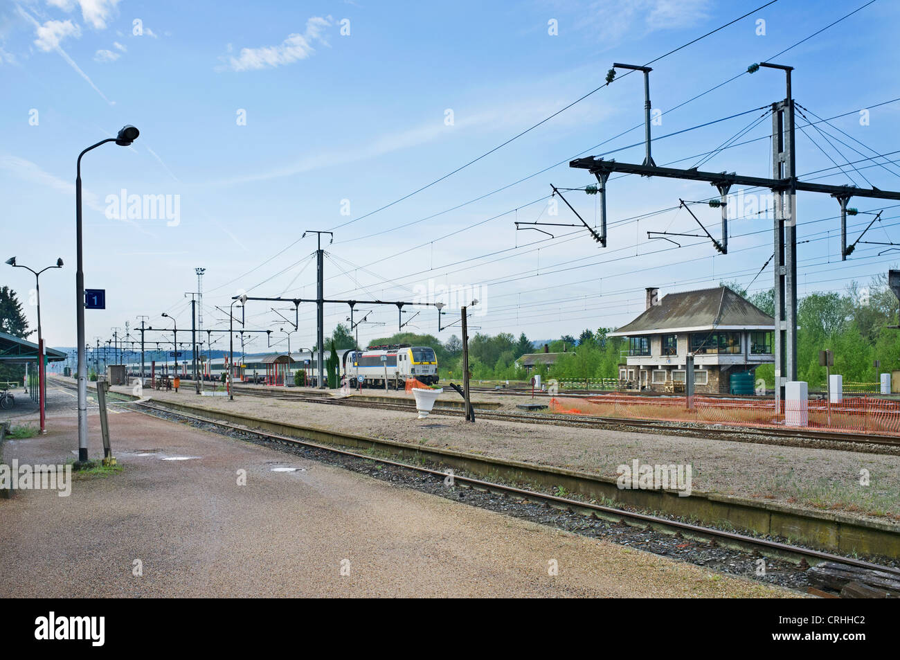 Empty railway station platform with train passing Stock Photo - Alamy