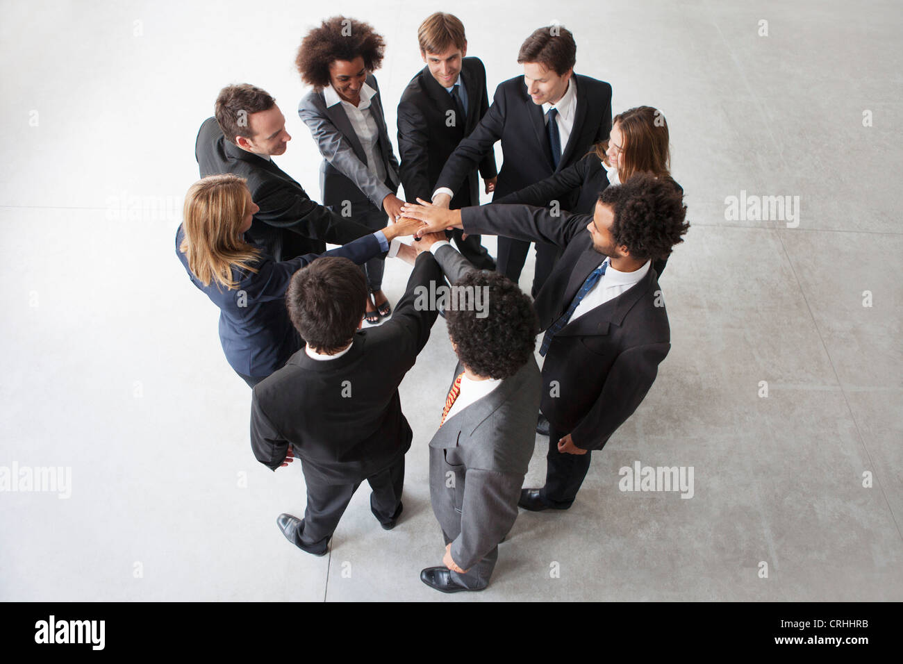 Business team members link hands in unity Stock Photo - Alamy
