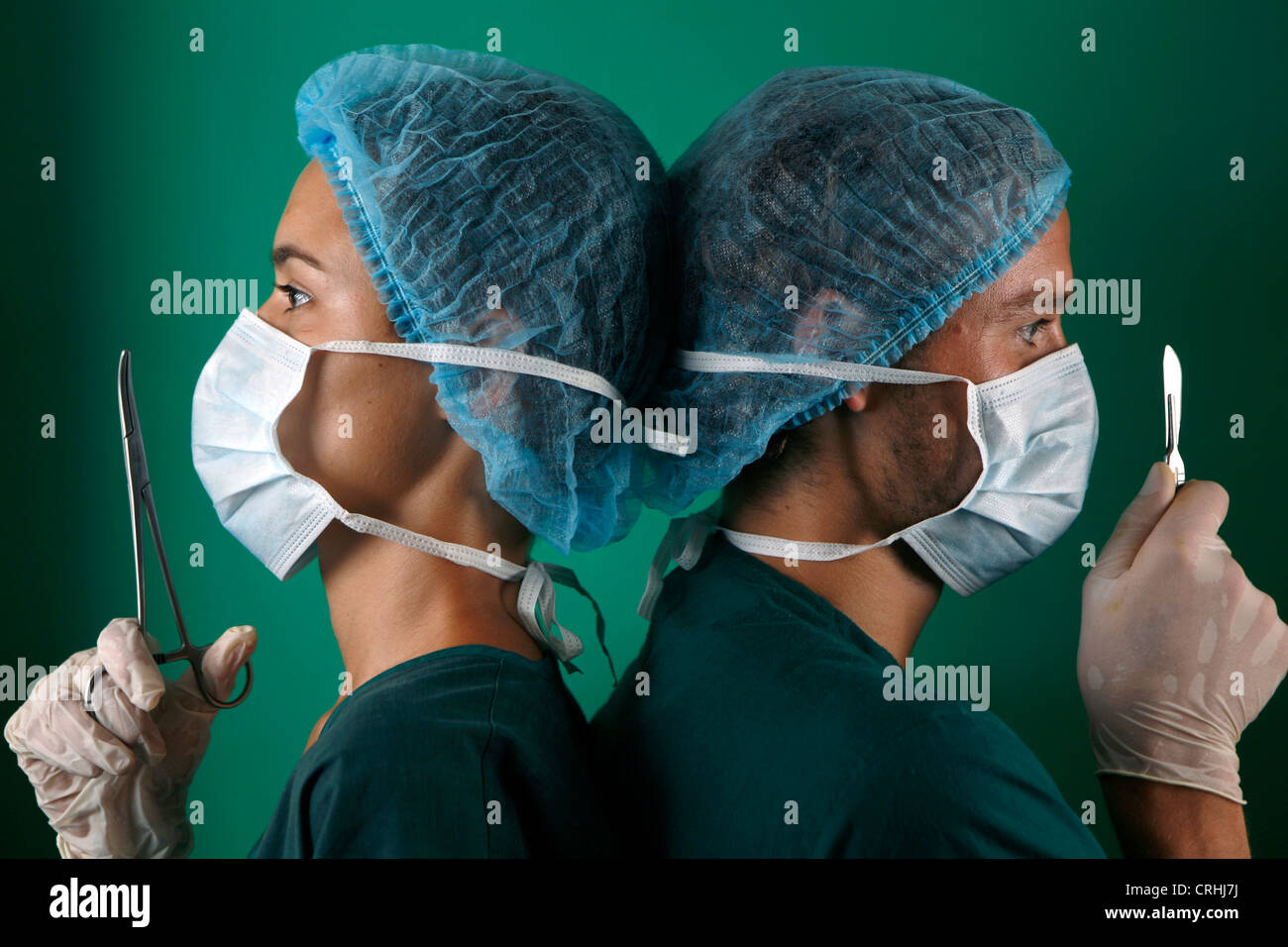two surgeons in front of a green background Stock Photo - Alamy