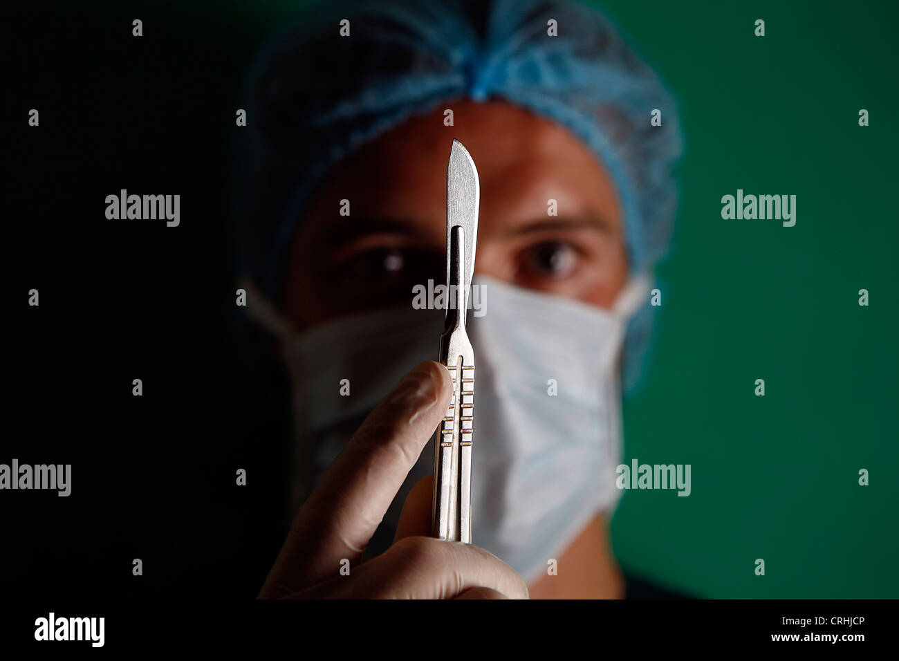 Surgeon holding a scalpel towards the camera Stock Photo - Alamy