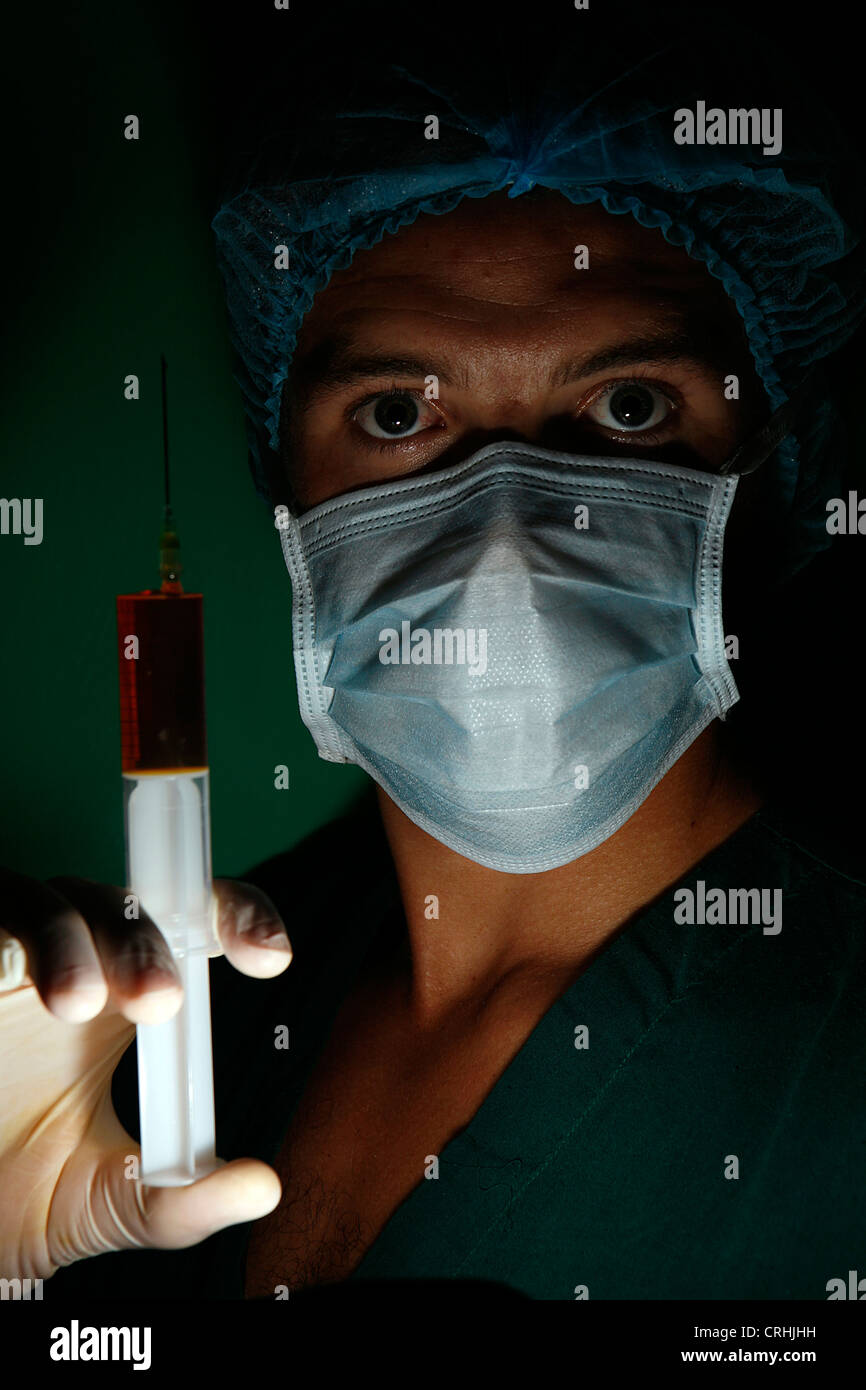 A surgeon holds a red liquid filled syringe Stock Photo - Alamy
