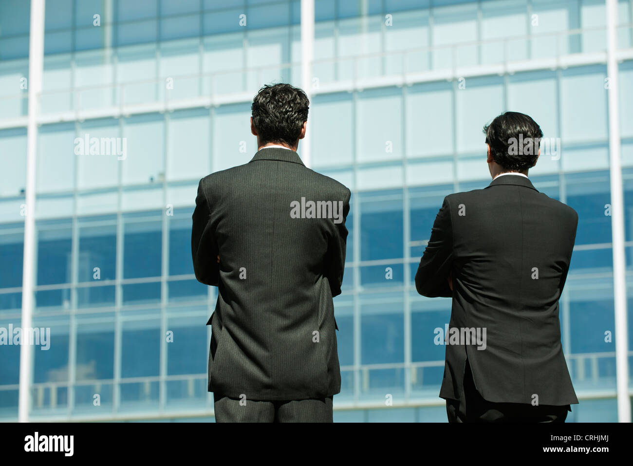 Executives standing in front of office building, rear view Stock Photo ...