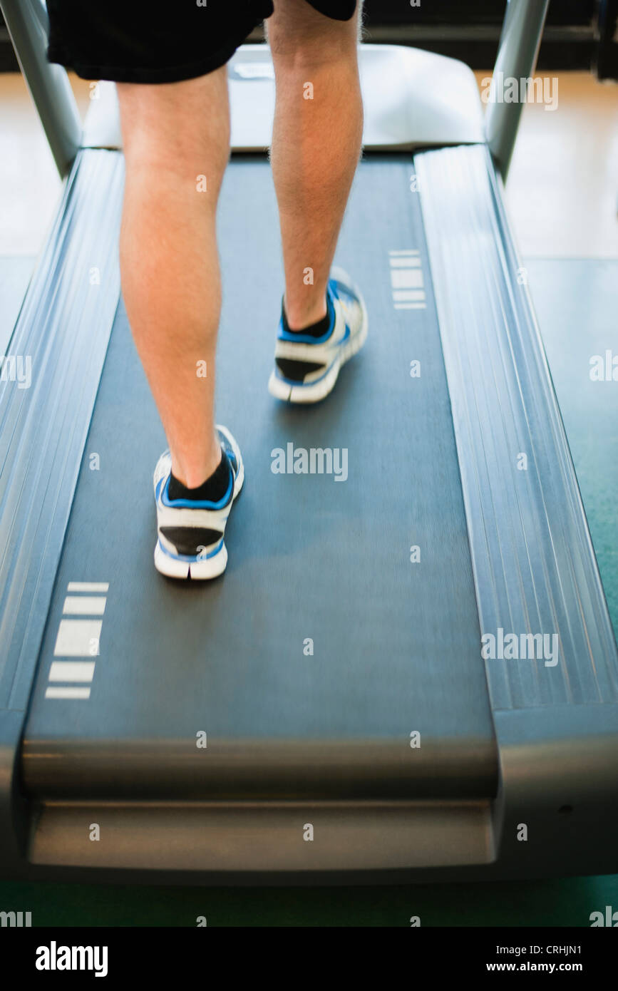 Man running on treadmill, low section, rear view Stock Photo - Alamy
