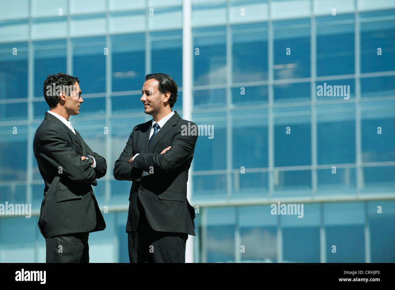 Business executives standing in front of office building talking Stock ...