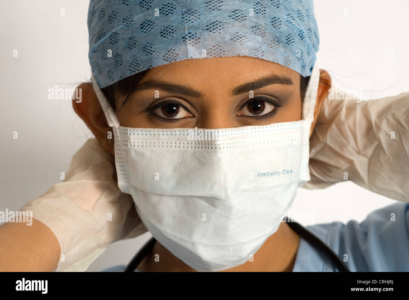 Close up of a female surgeon wearing a surgical mask and hygiene hat ...