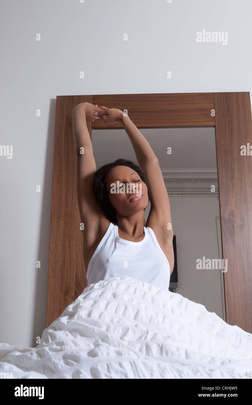 Woman stretching in bed Stock Photo - Alamy