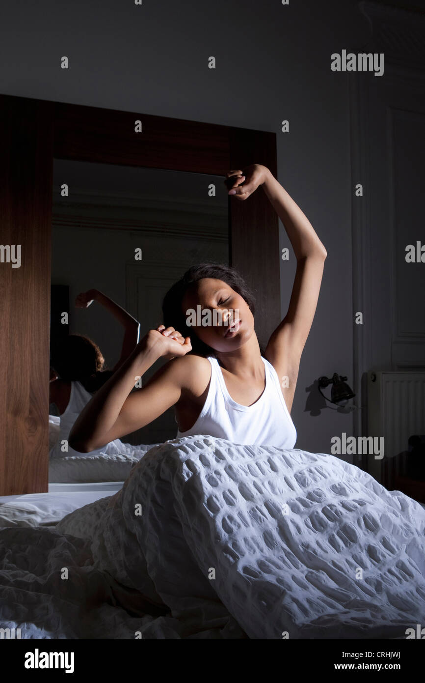 Woman stretching in bed Stock Photo - Alamy