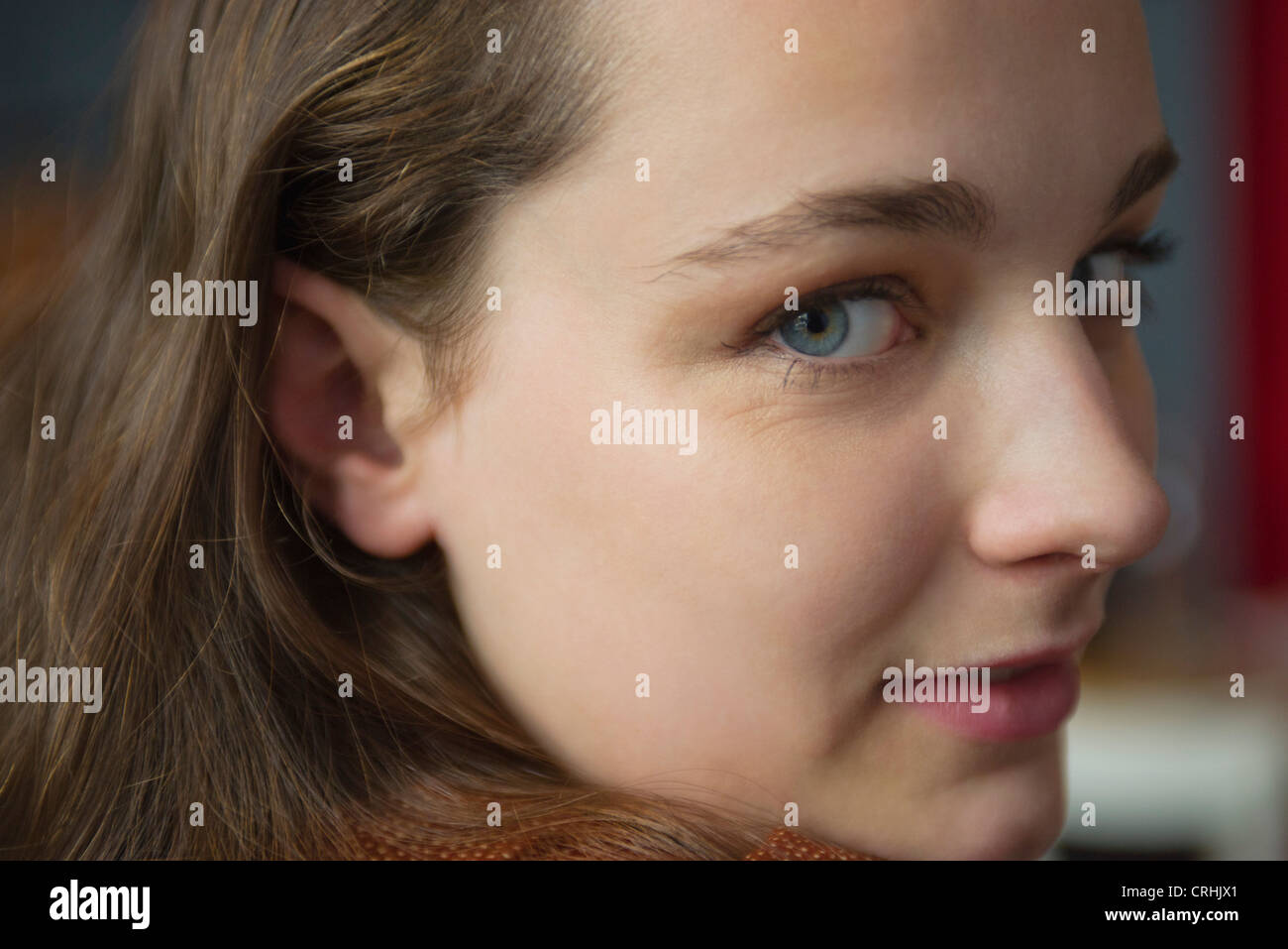 Young woman looking over shoulder, portrait Stock Photo - Alamy